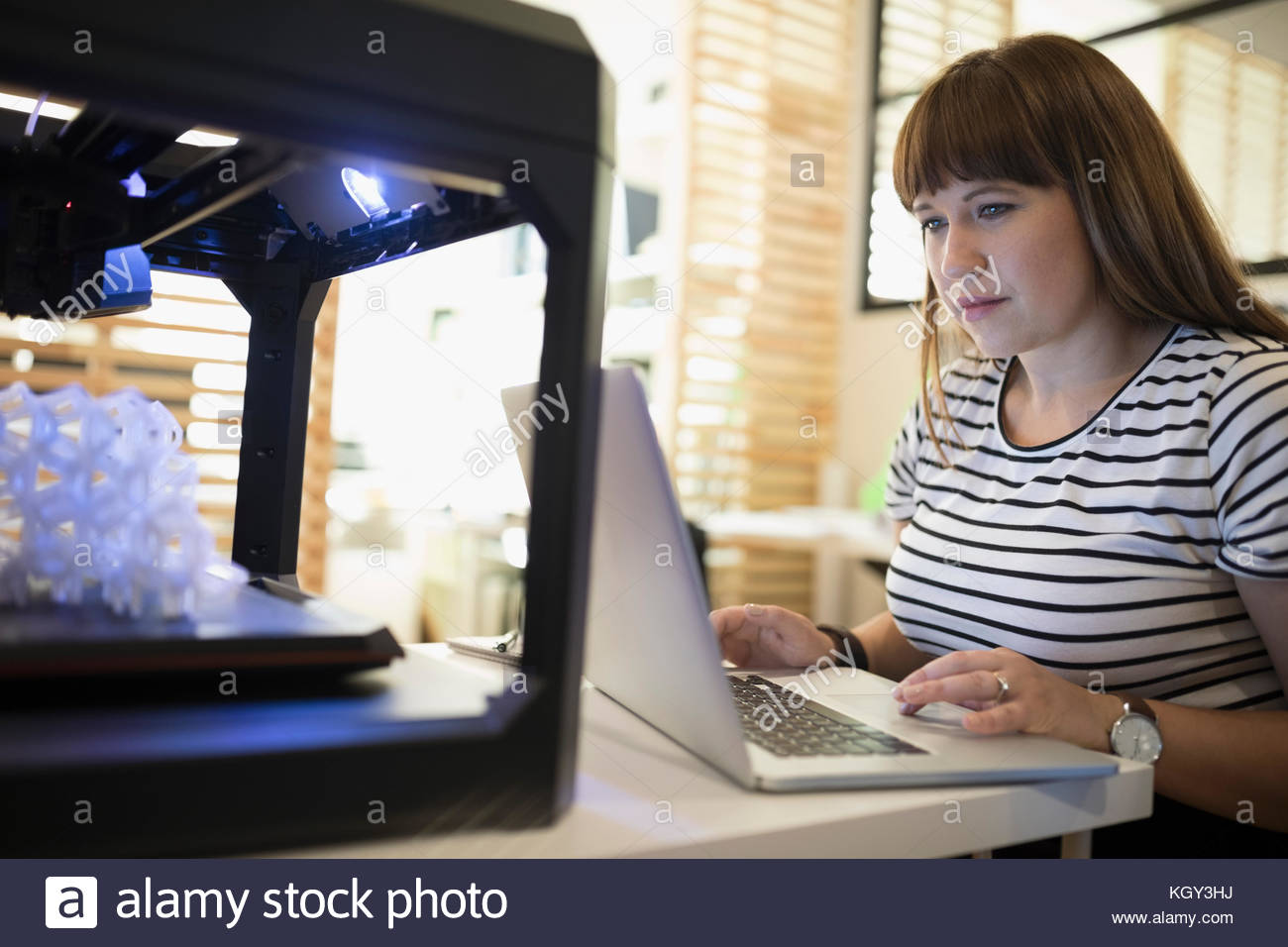 Female designer using laptop at 3D printer in office Stock Photo - Alamy