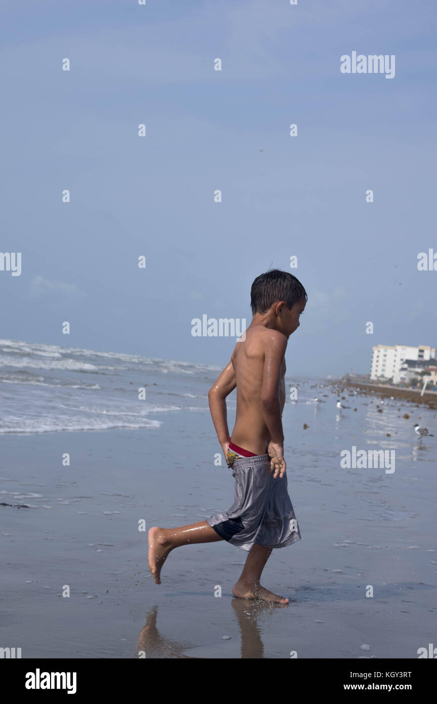 brown boy playing on beach Stock Photo - Alamy