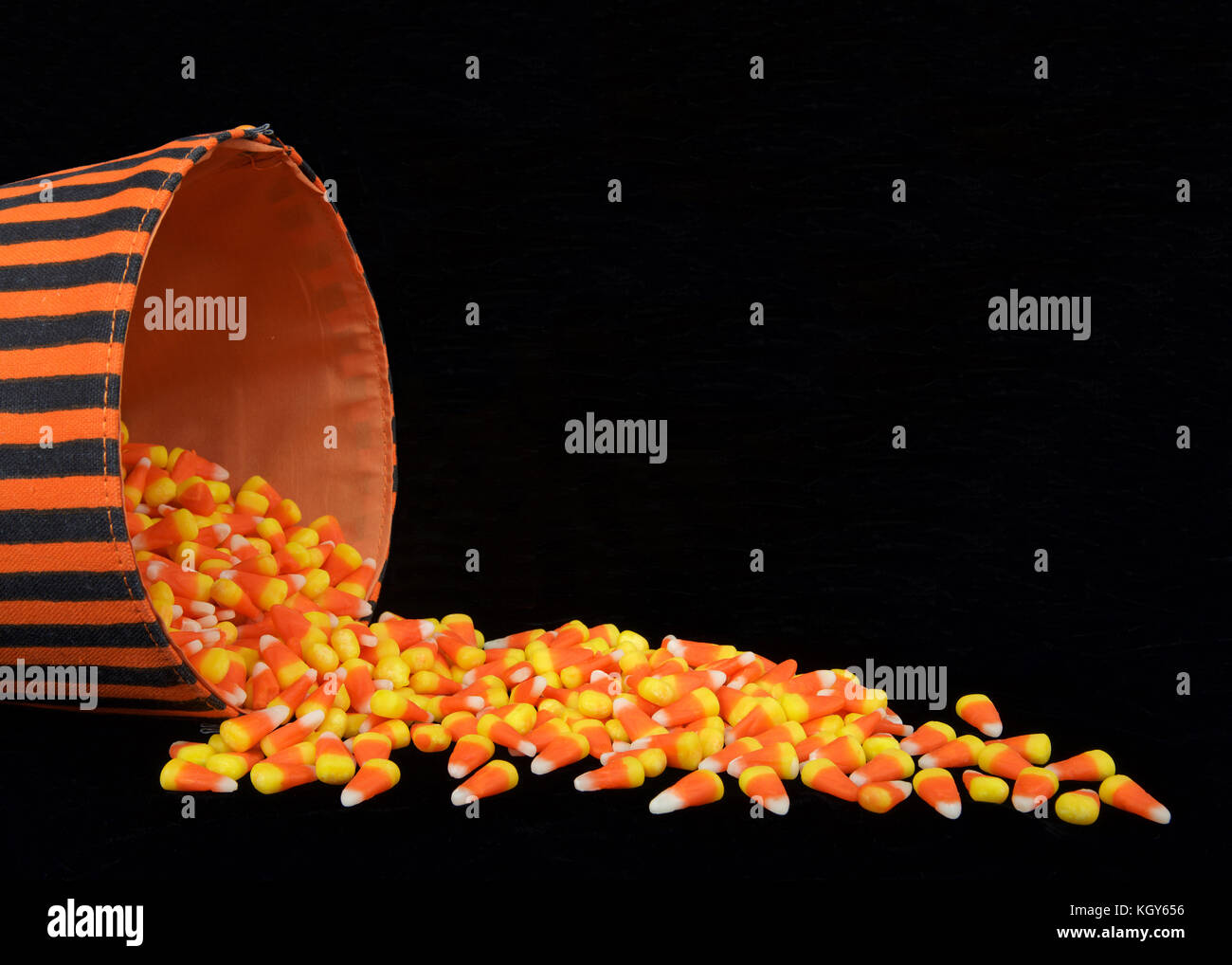 Candy corn traditional to Halloween spilling out of a black and orange ...