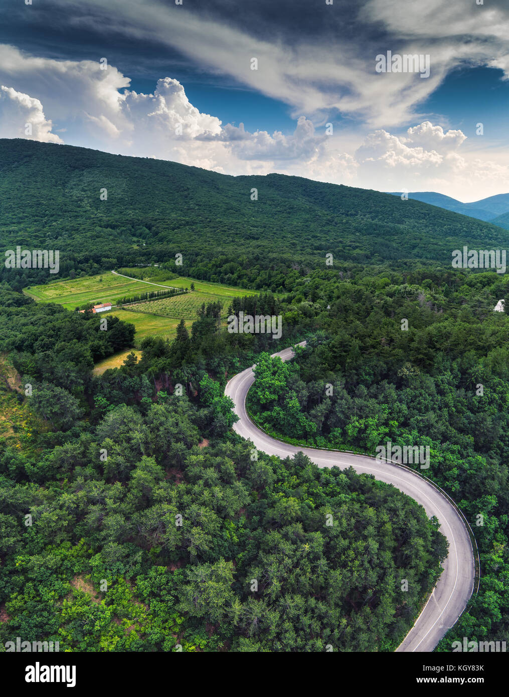 Aerial view over mountain road going through forest landscape Stock ...