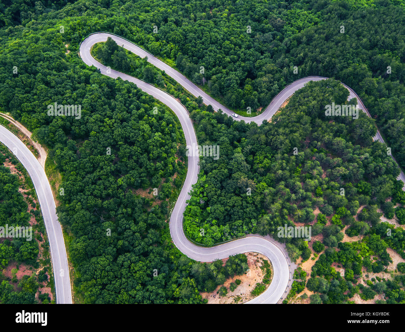 Aerial view over mountain road going through forest landscape Stock ...