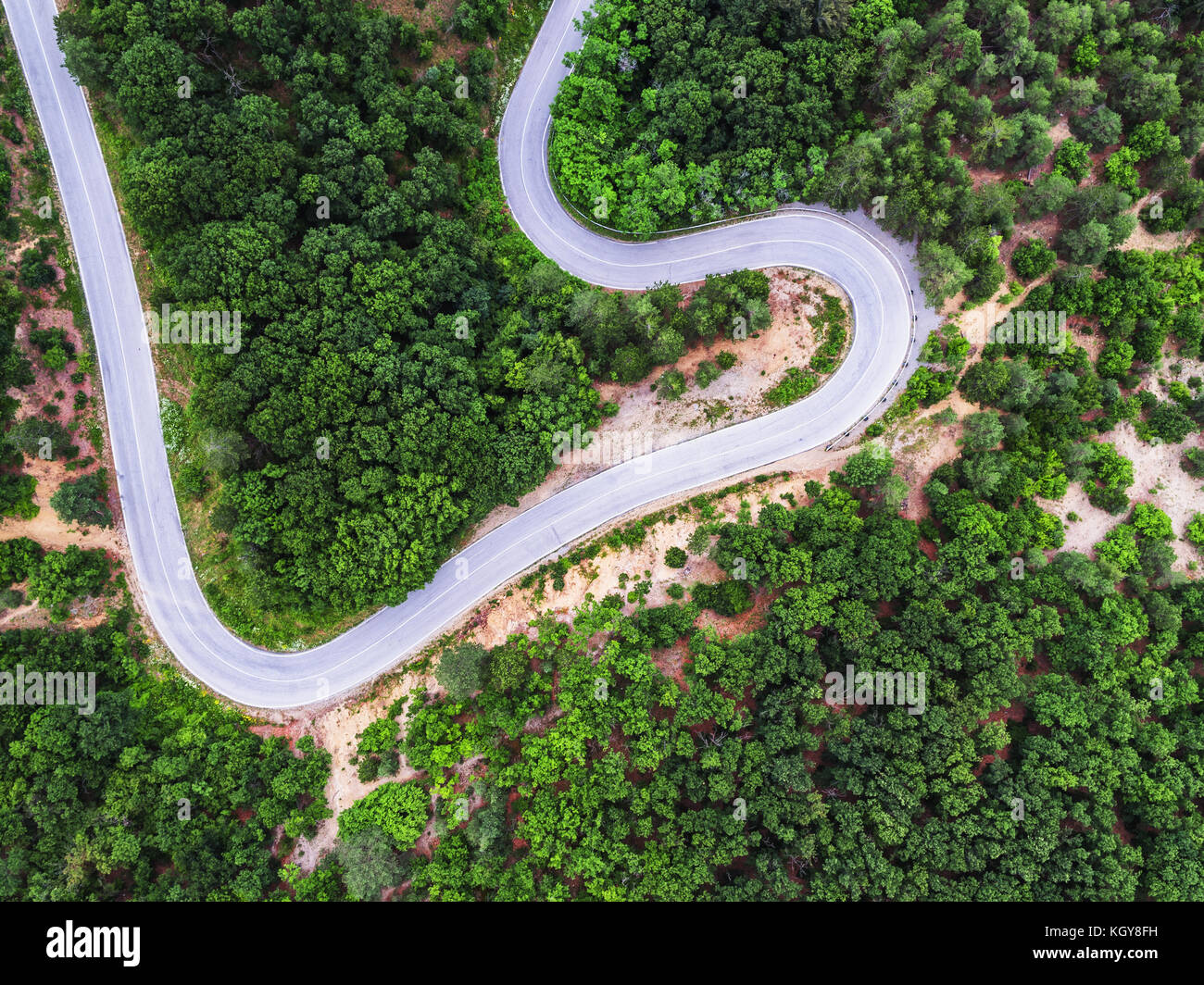 Aerial view over mountain road going through forest landscape Stock ...