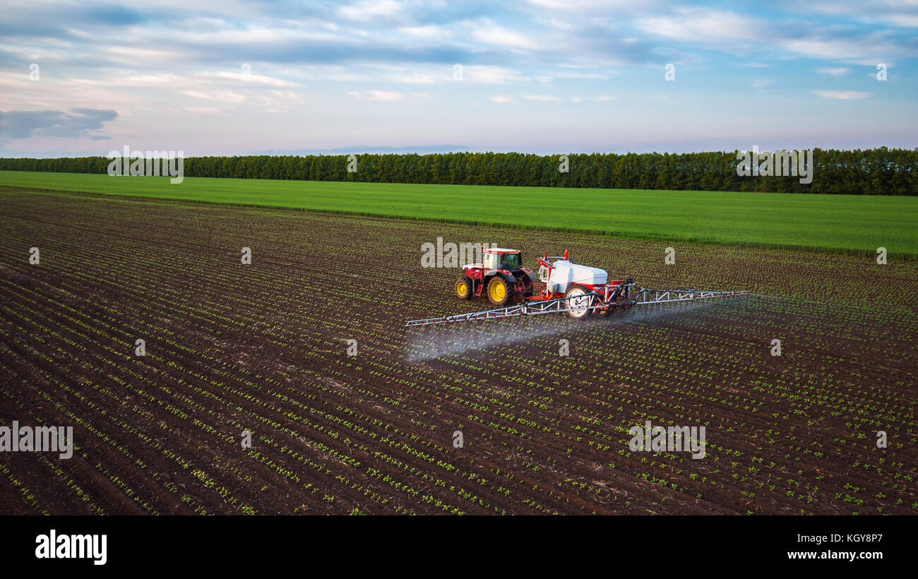 Farming tractor spraying on field at spring, aerial view Stock Photo ...