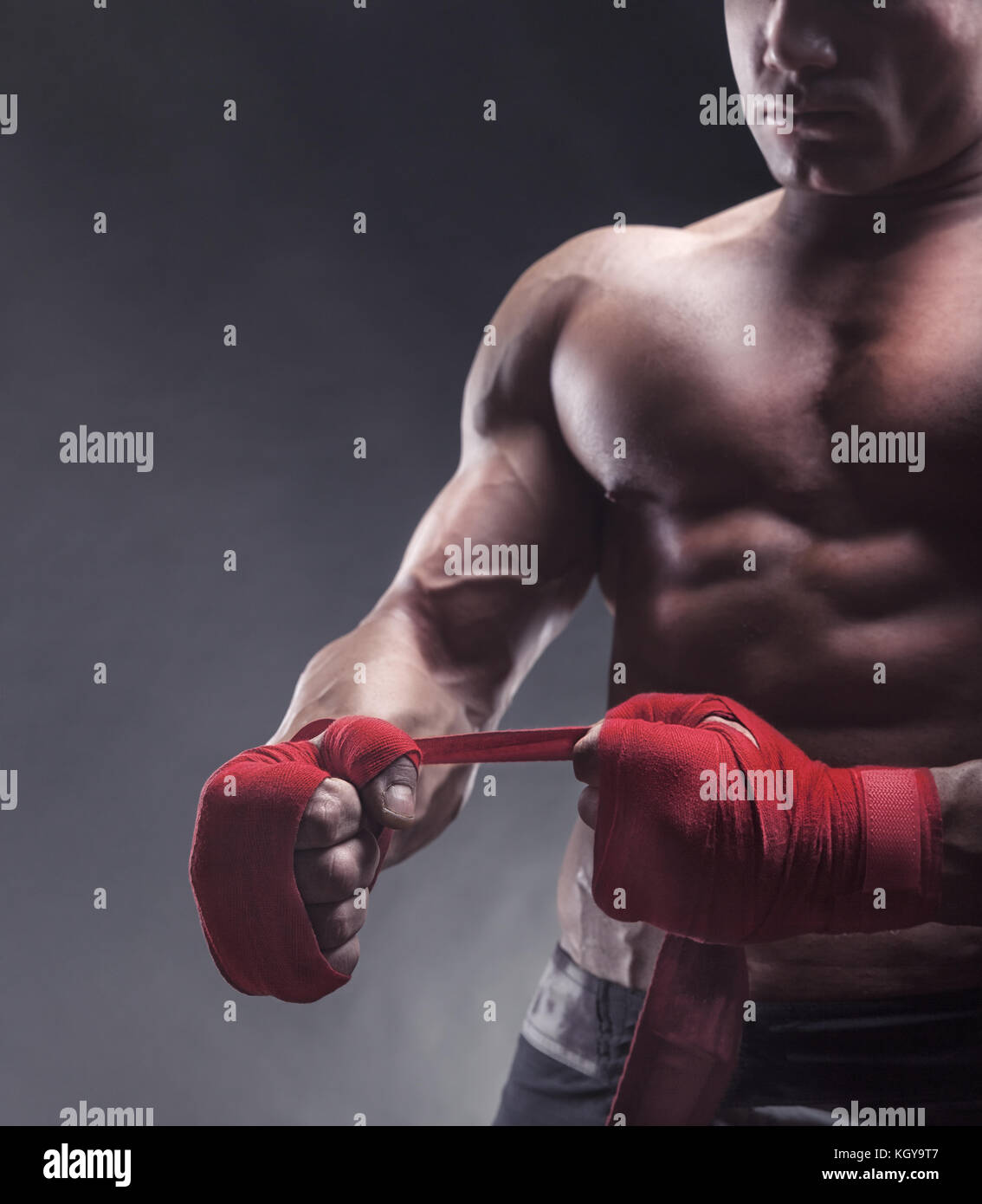Close-up of a strong boxer putting on red straps and getting ready to ...