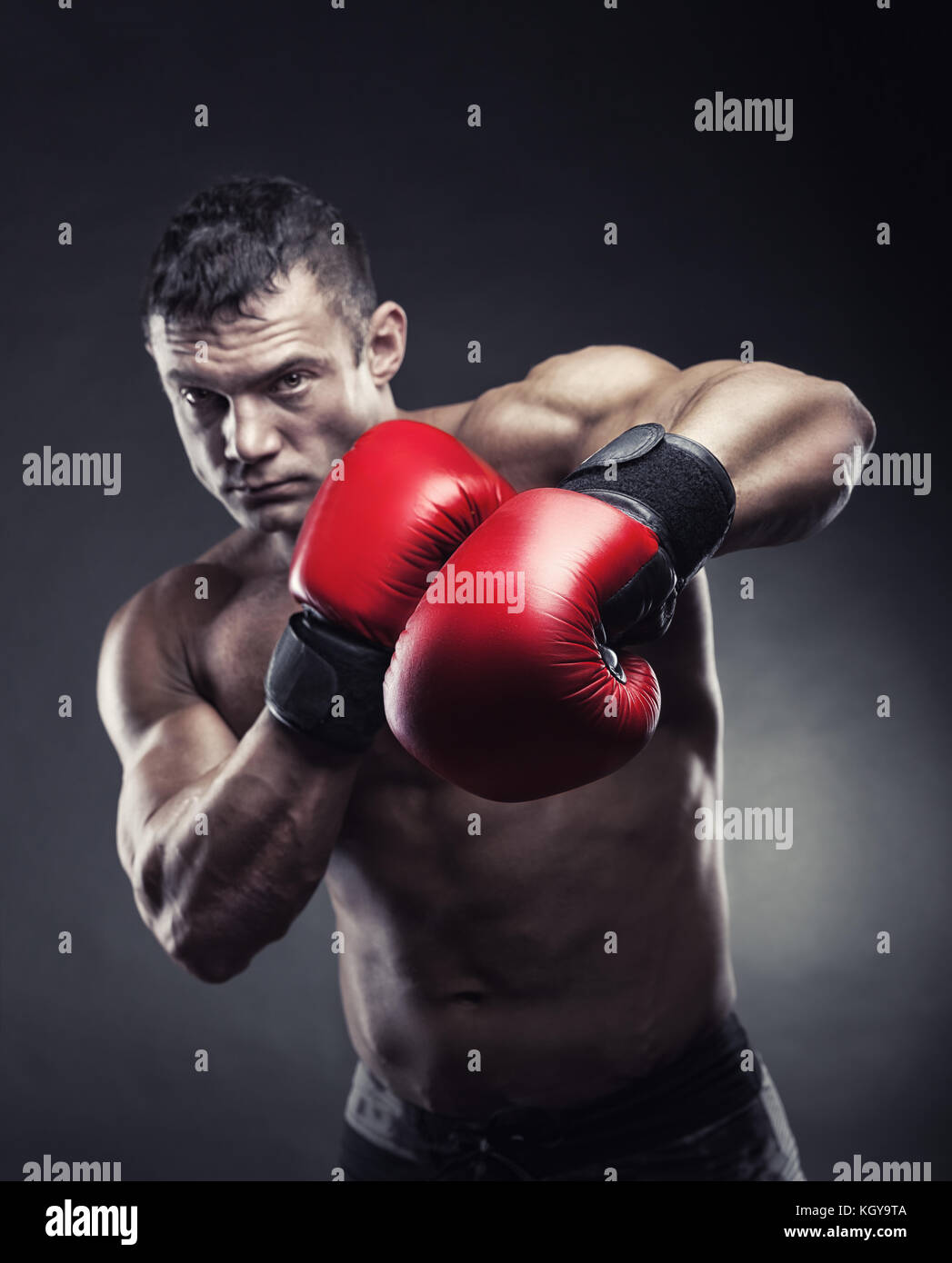 Boxing concept. Boxer with an aggressive look in red boxing gloves ...