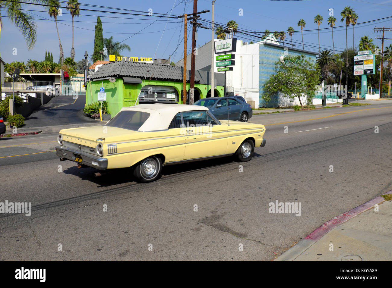 Classic yellow car driving past Mixto Mexican restaurant on Hyperion ...