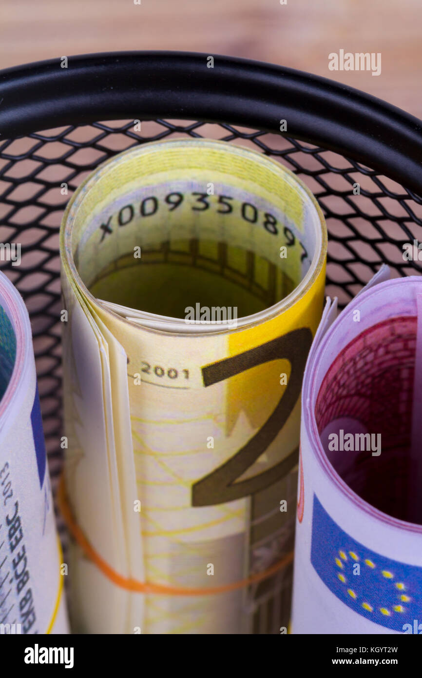 Bankroll cash euro banknotes in garbage basket focused on consuming in ...