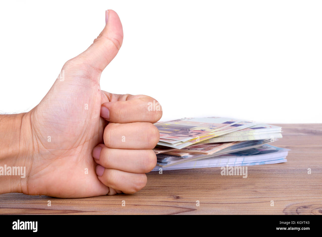 Stack of euro banknotes on man hand on wooden table focused on saving ...