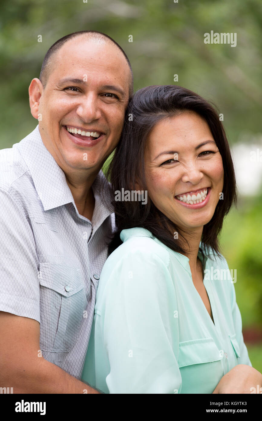 Happy mixed race couple smiling and hugging outside Stock Photo - Alamy