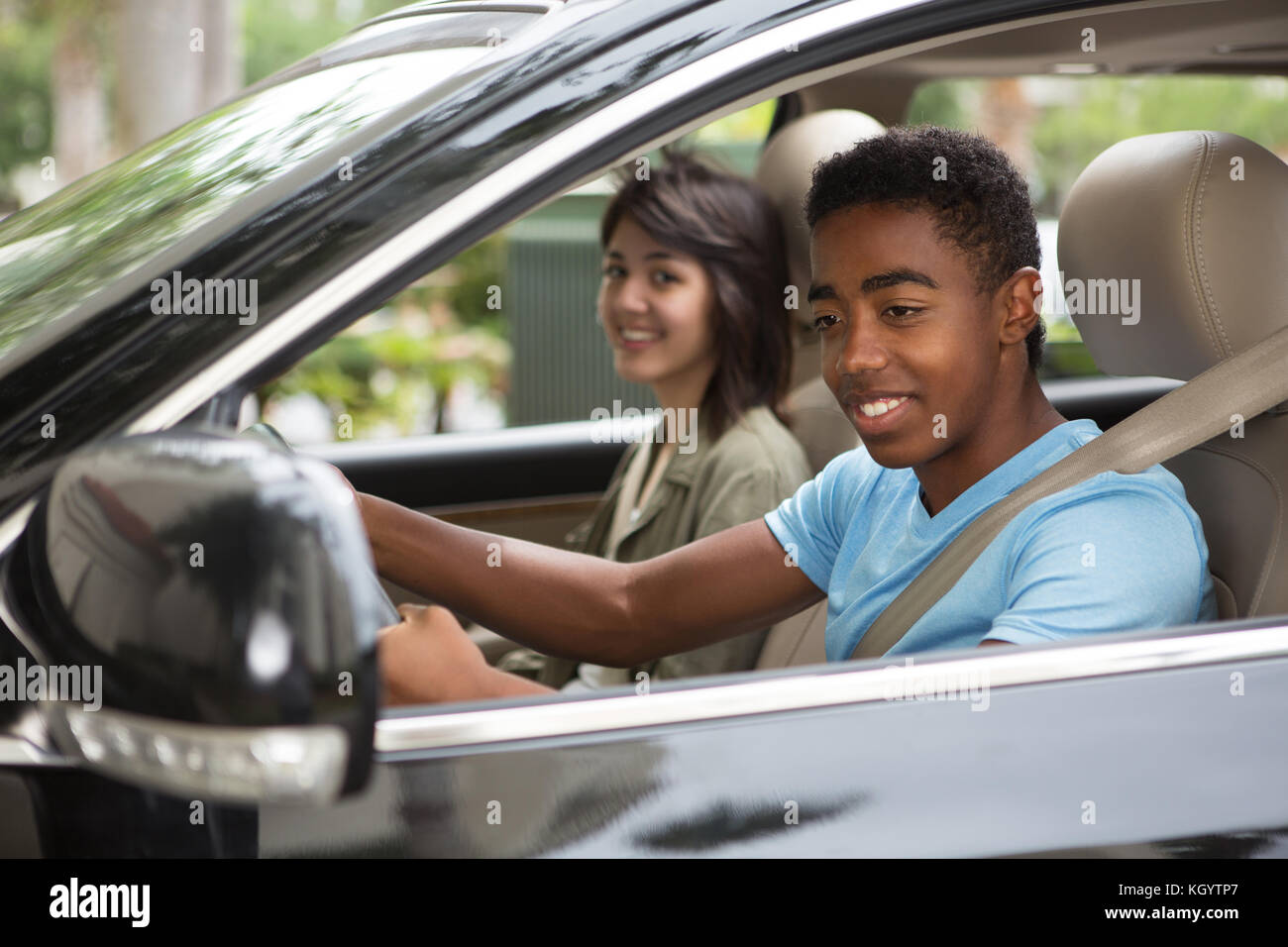 Two teenage friends laughing and talking while driving Stock Photo - Alamy