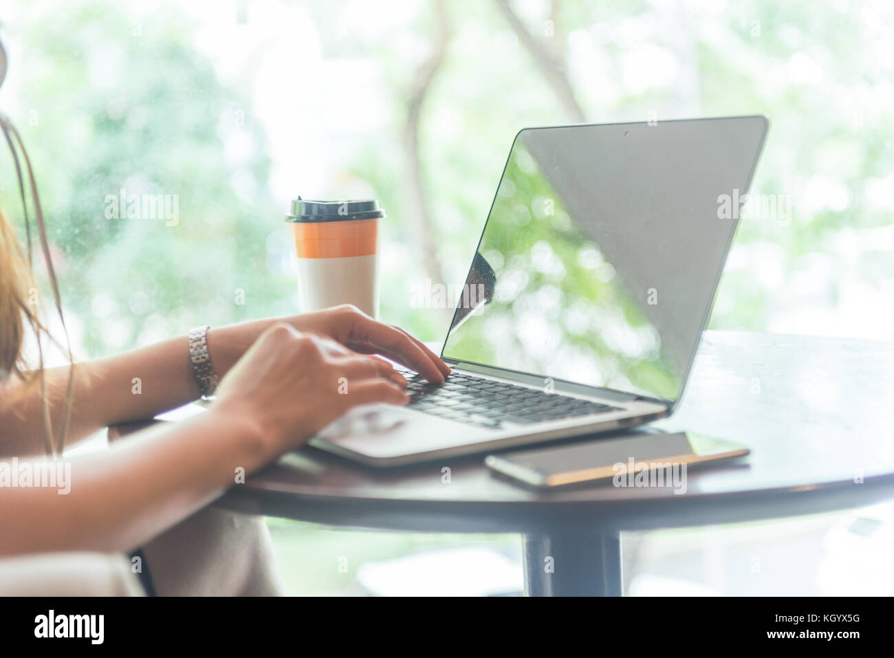 Side view of female hands using laptop Stock Photo - Alamy
