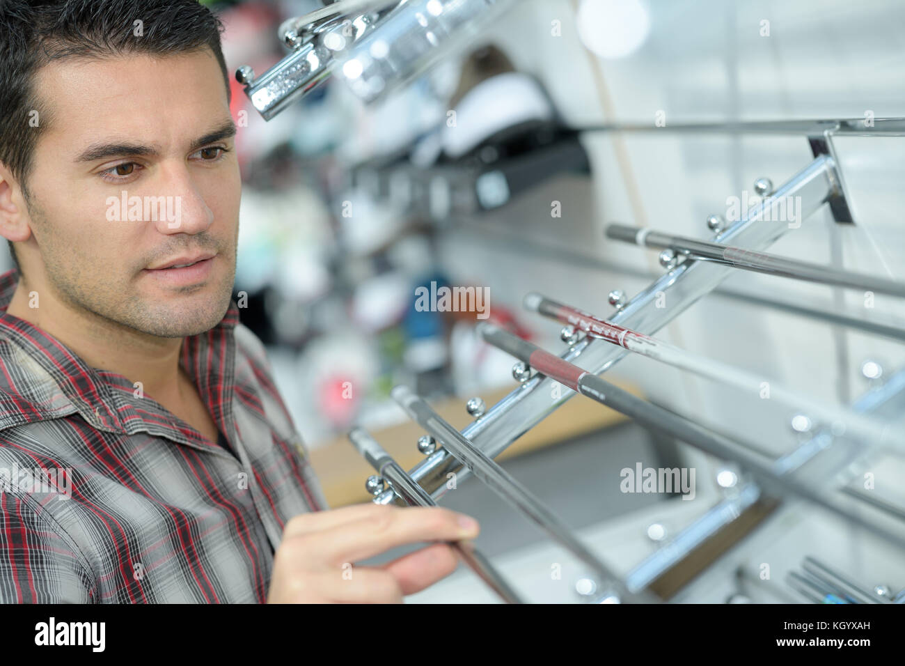 man viewing metal rack Stock Photo - Alamy