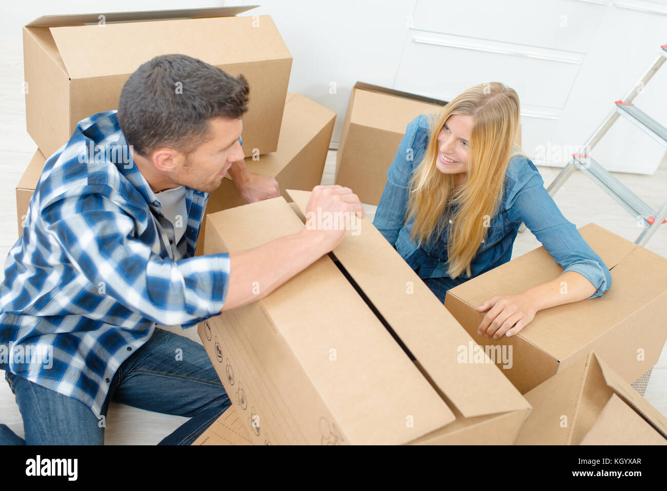 Young couple unpacking boxes Stock Photo - Alamy