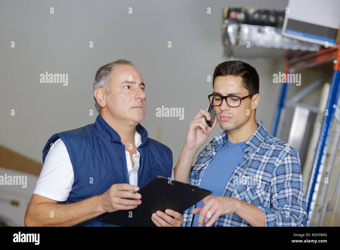 manager and man calling on phone at workshop warehouse Stock Photo - Alamy