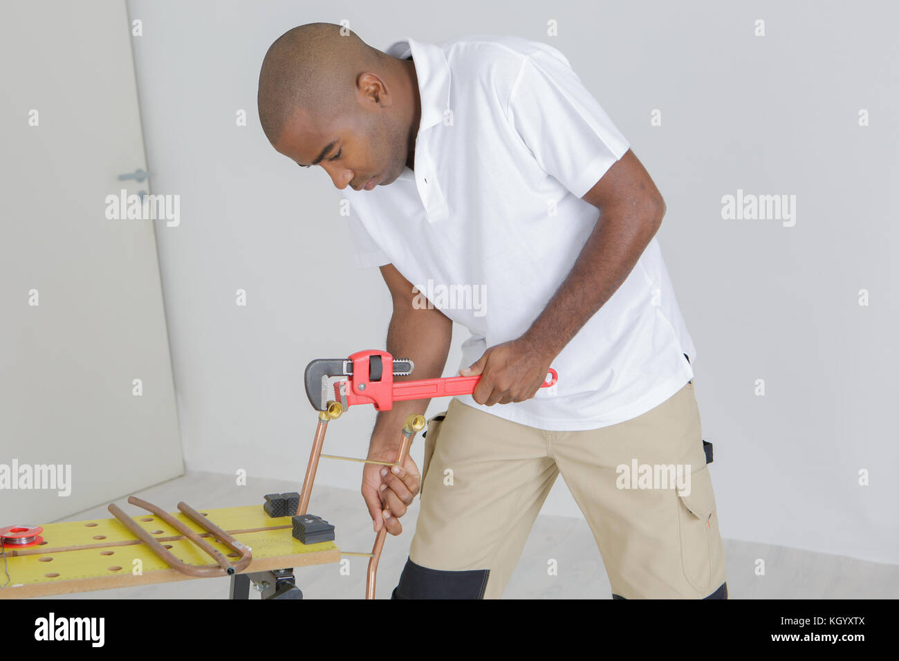 Man using wrench on copper pipe Stock Photo - Alamy