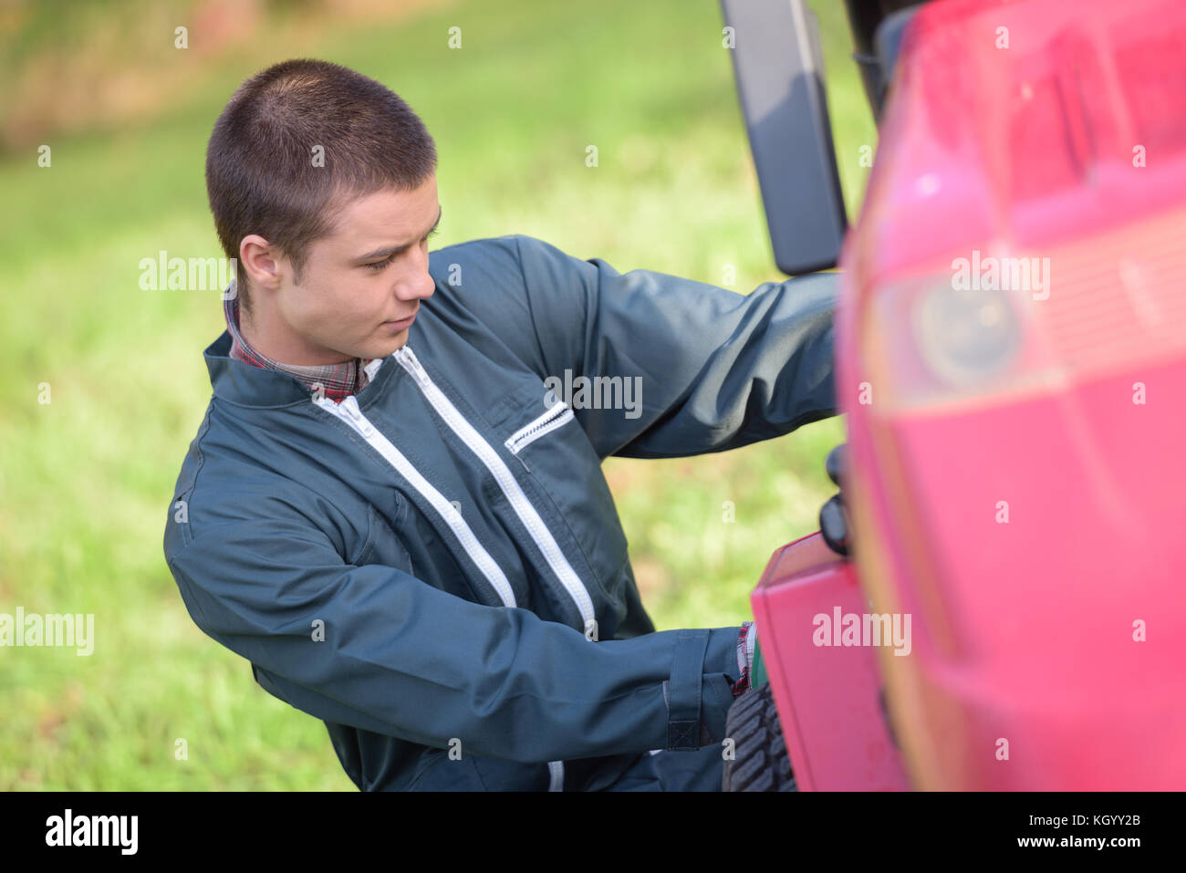 Young man working on mower Stock Photo - Alamy