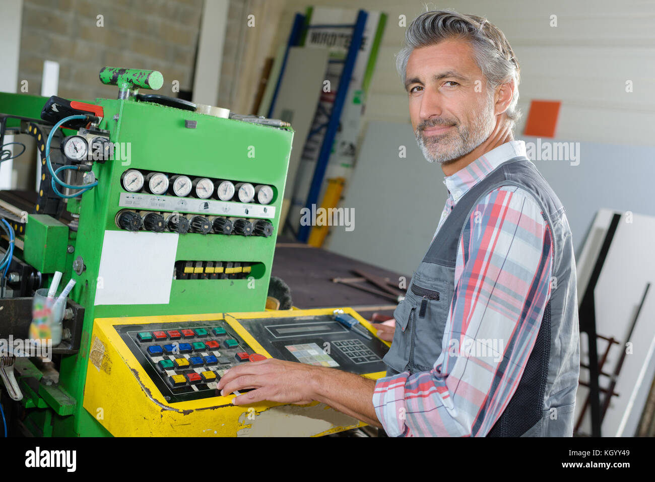 worker tending a machine Stock Photo - Alamy