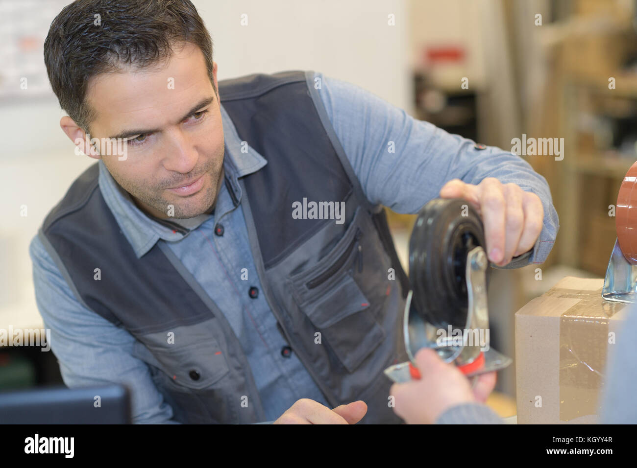 man repairing trolley wheel in workshop Stock Photo - Alamy