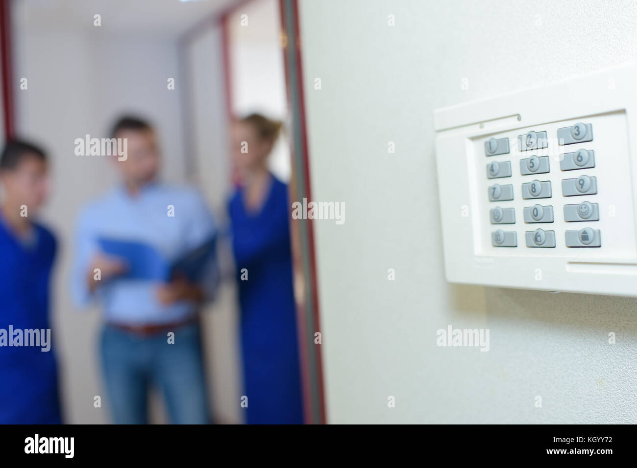 Closeup of wall mounted keypad, people in background Stock Photo - Alamy