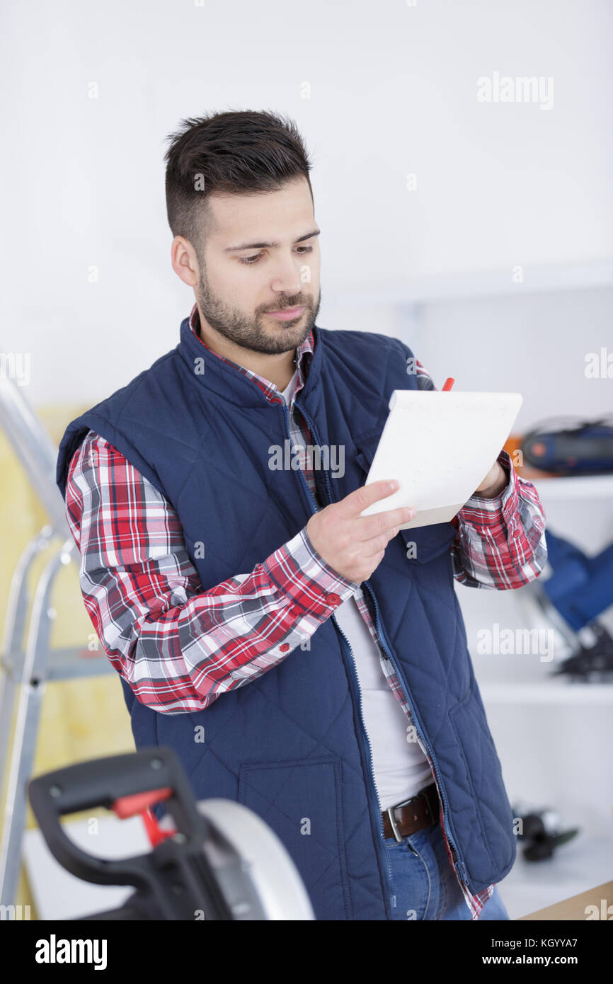 worker checking his list in a large warehouse Stock Photo - Alamy