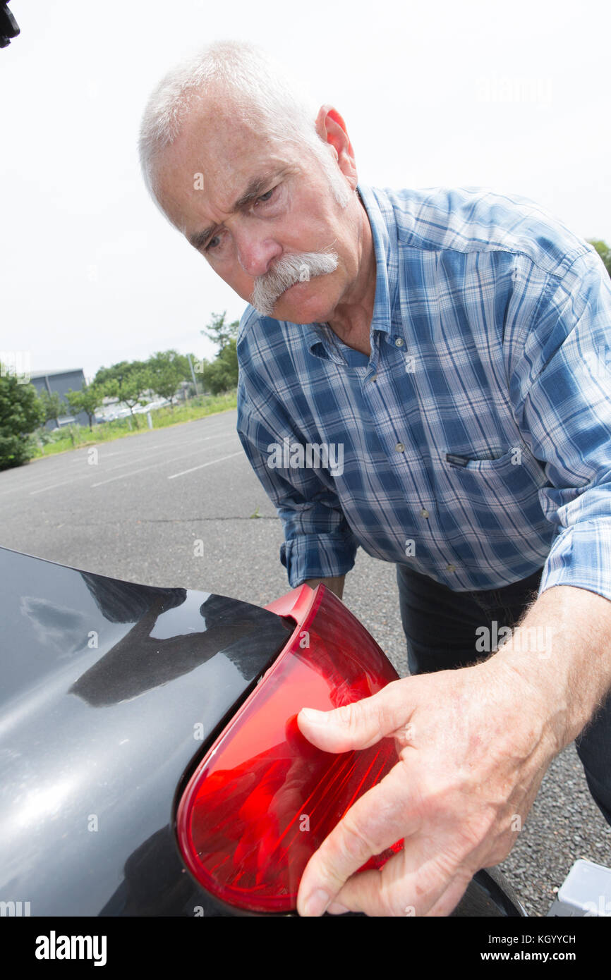 old man installs tail light on the vehicle Stock Photo - Alamy