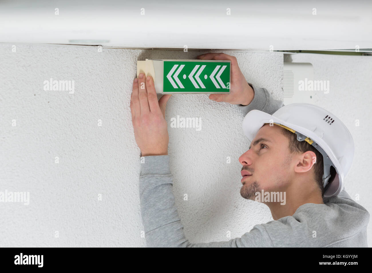 a male electrician fixing electric sign on the ceiling Stock Photo - Alamy