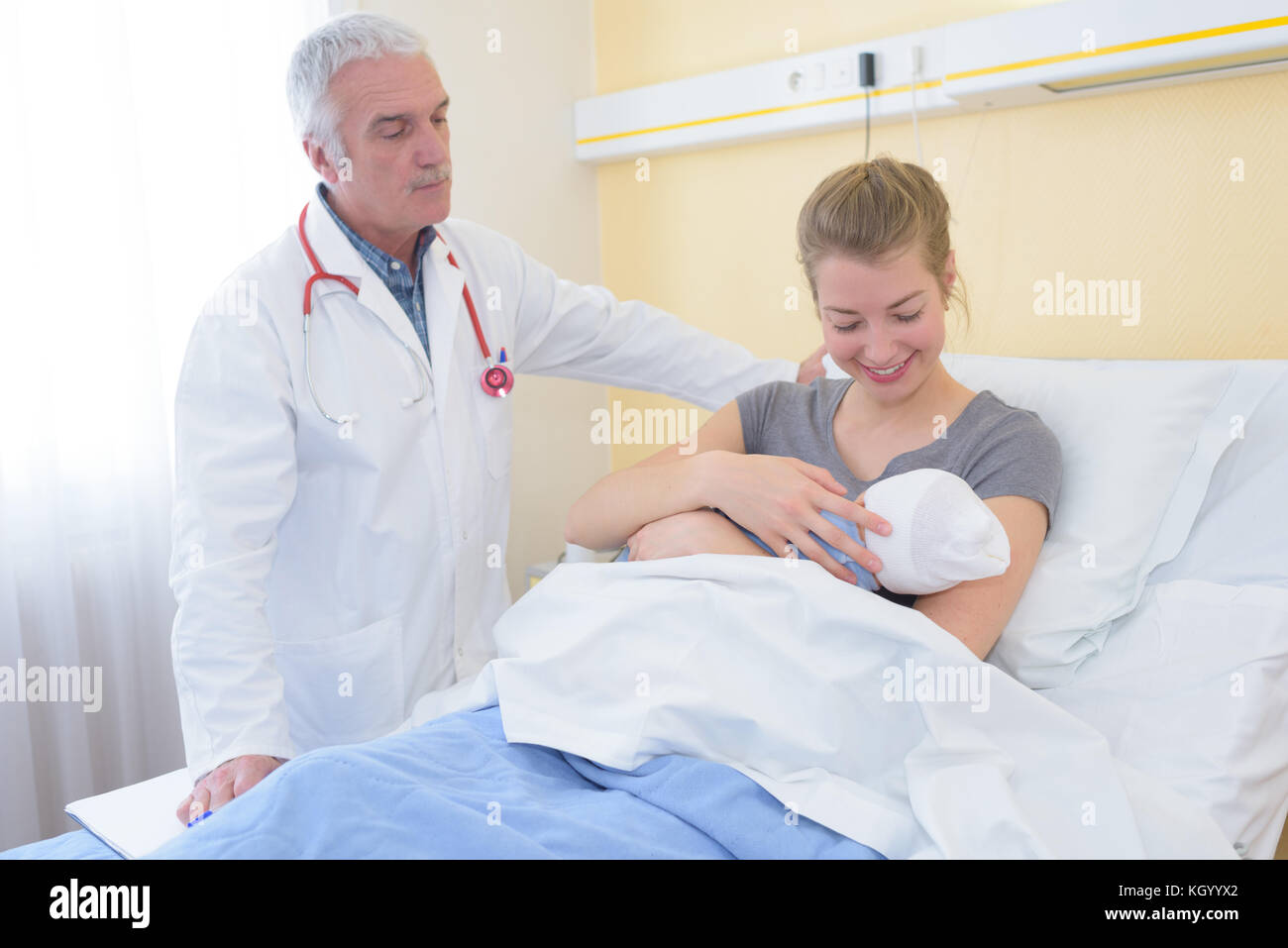 Doctor watching mother and newborn baby Stock Photo - Alamy