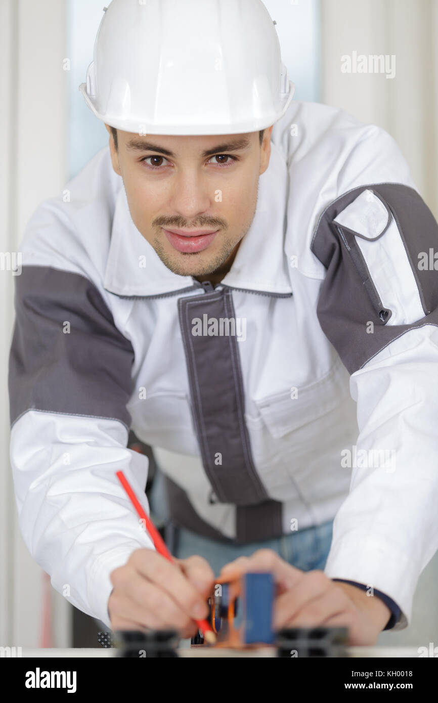 carpenter with ruler measuring wood plank at a construction site Stock ...