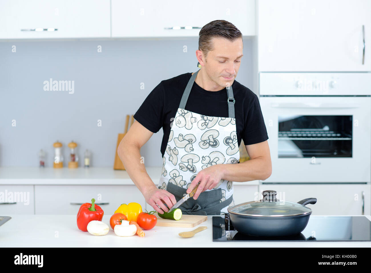 attractive man cooking in a kitchen Stock Photo - Alamy