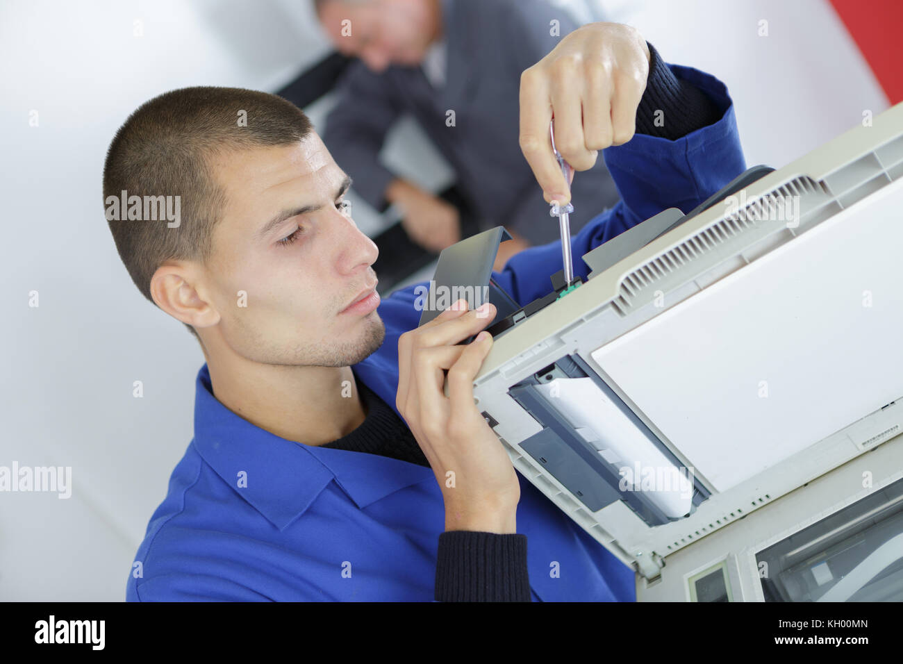 apprentice fixing a printer machine Stock Photo - Alamy