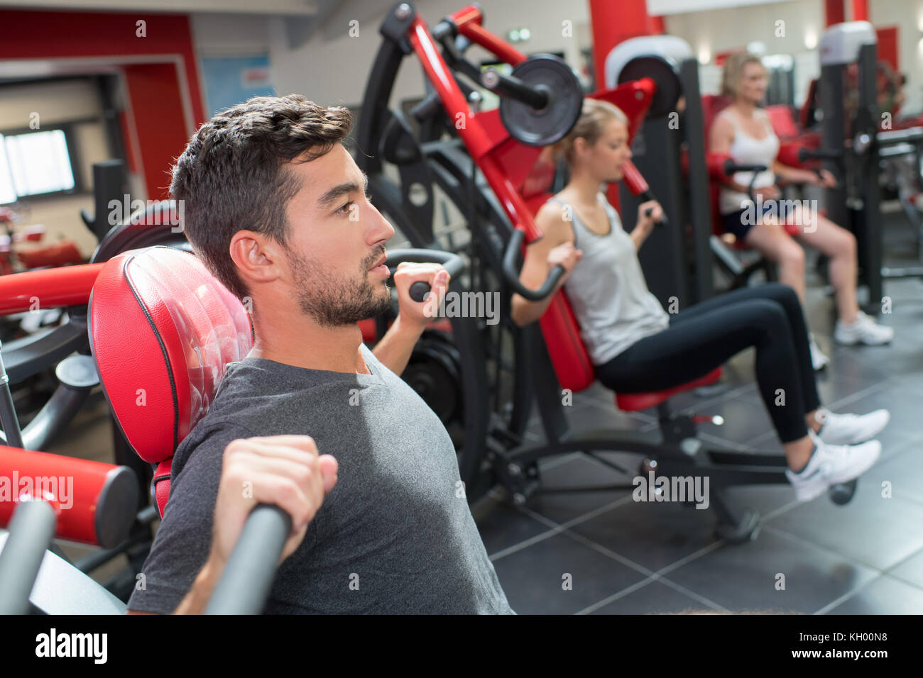 sport people working out muscles on weight lifting gym machine Stock ...