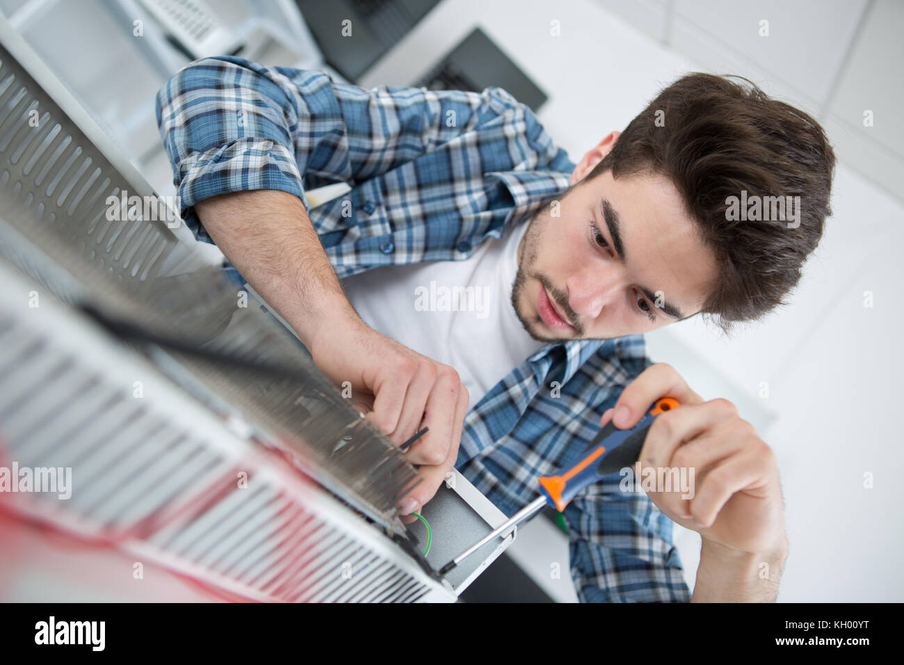 serious man repairing broken machine Stock Photo - Alamy