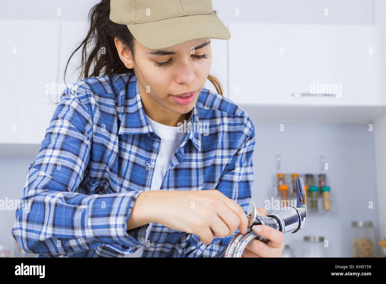 Woman plumbing in new tap Stock Photo - Alamy