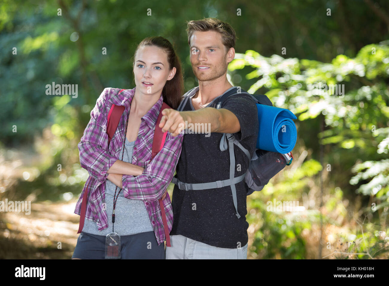 hiker couple pointing at distance in forest Stock Photo - Alamy