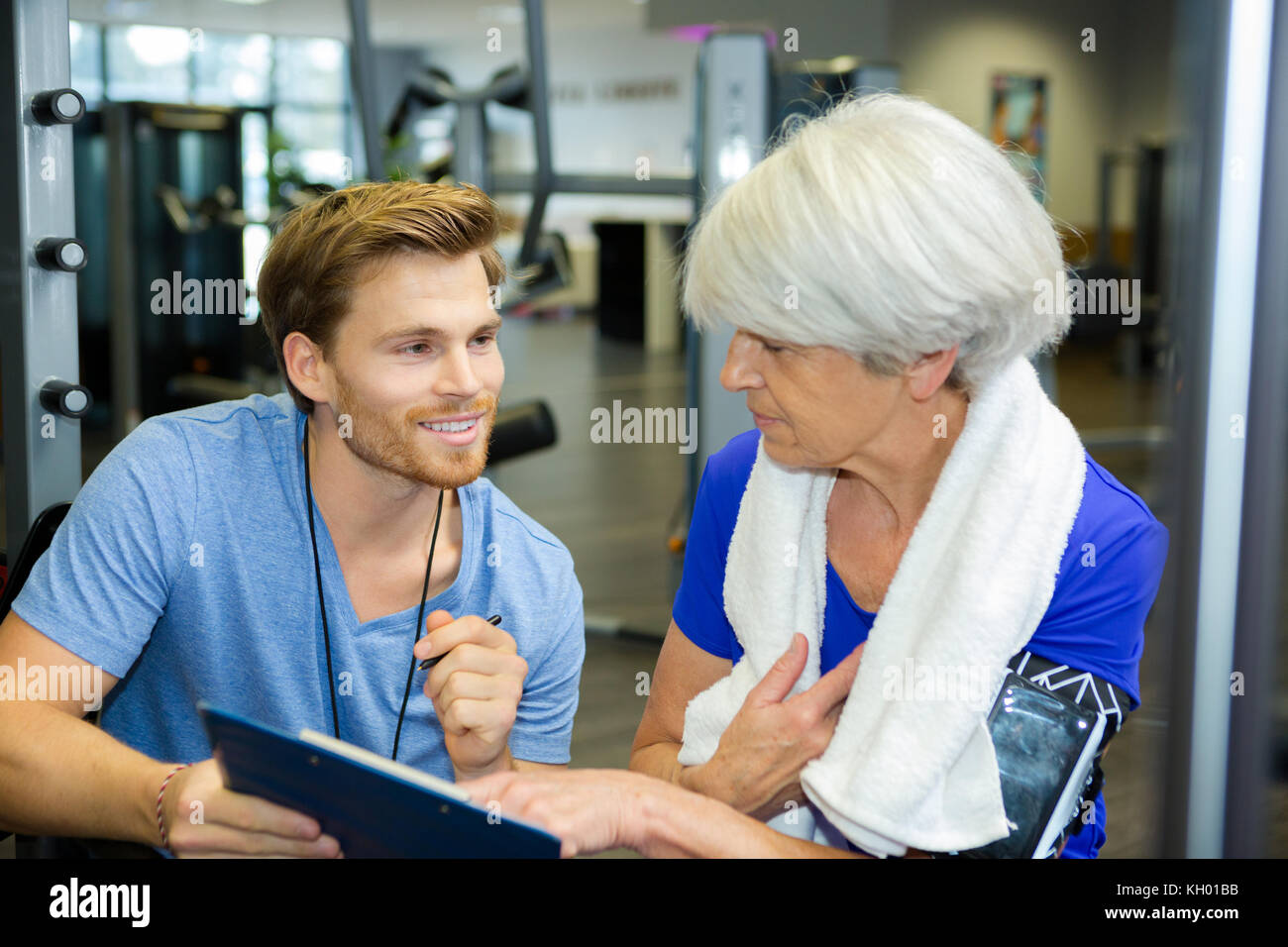 lady working out with friendly smiling young male trainer Stock Photo ...
