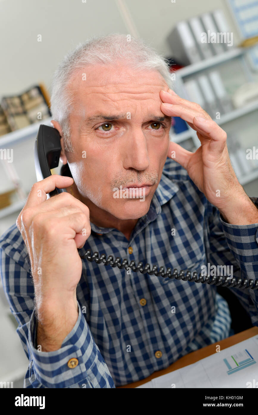 Stressed office worker on the phone Stock Photo - Alamy