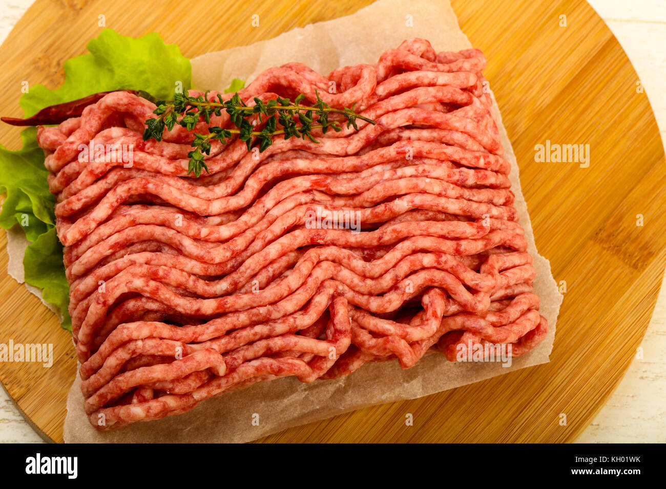 Raw minced beef meat with thyme and hot pepper Stock Photo - Alamy