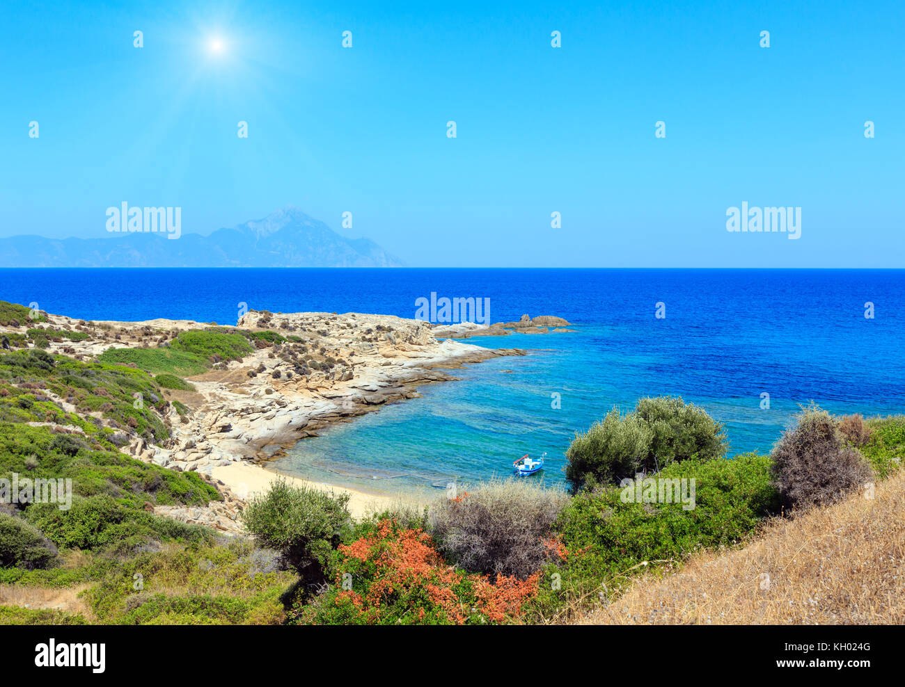 Summer sunshine stony sea coast landscape with Athos mount view in far ...