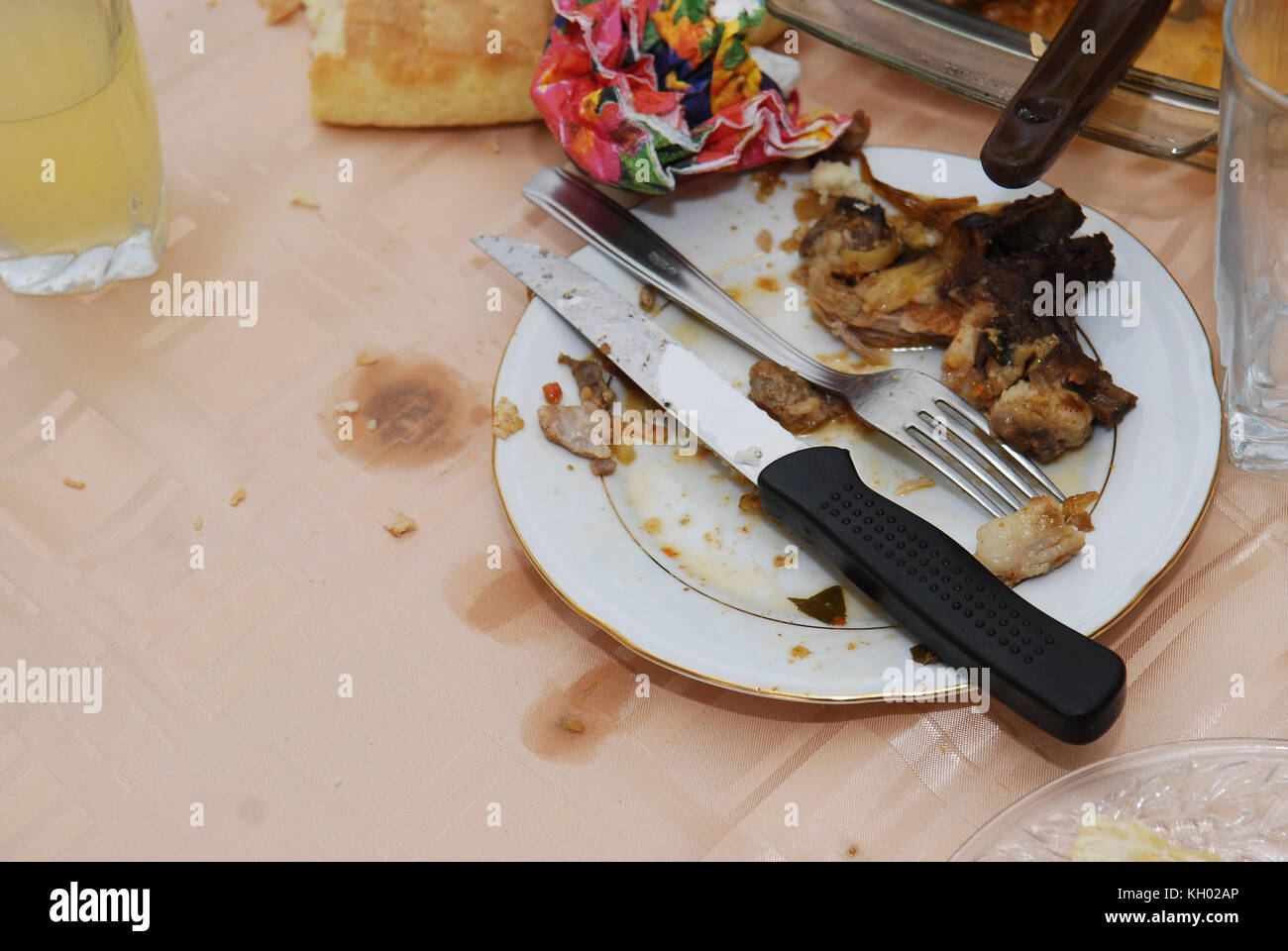 Messy table with plate and glasses after lunch Stock Photo - Alamy