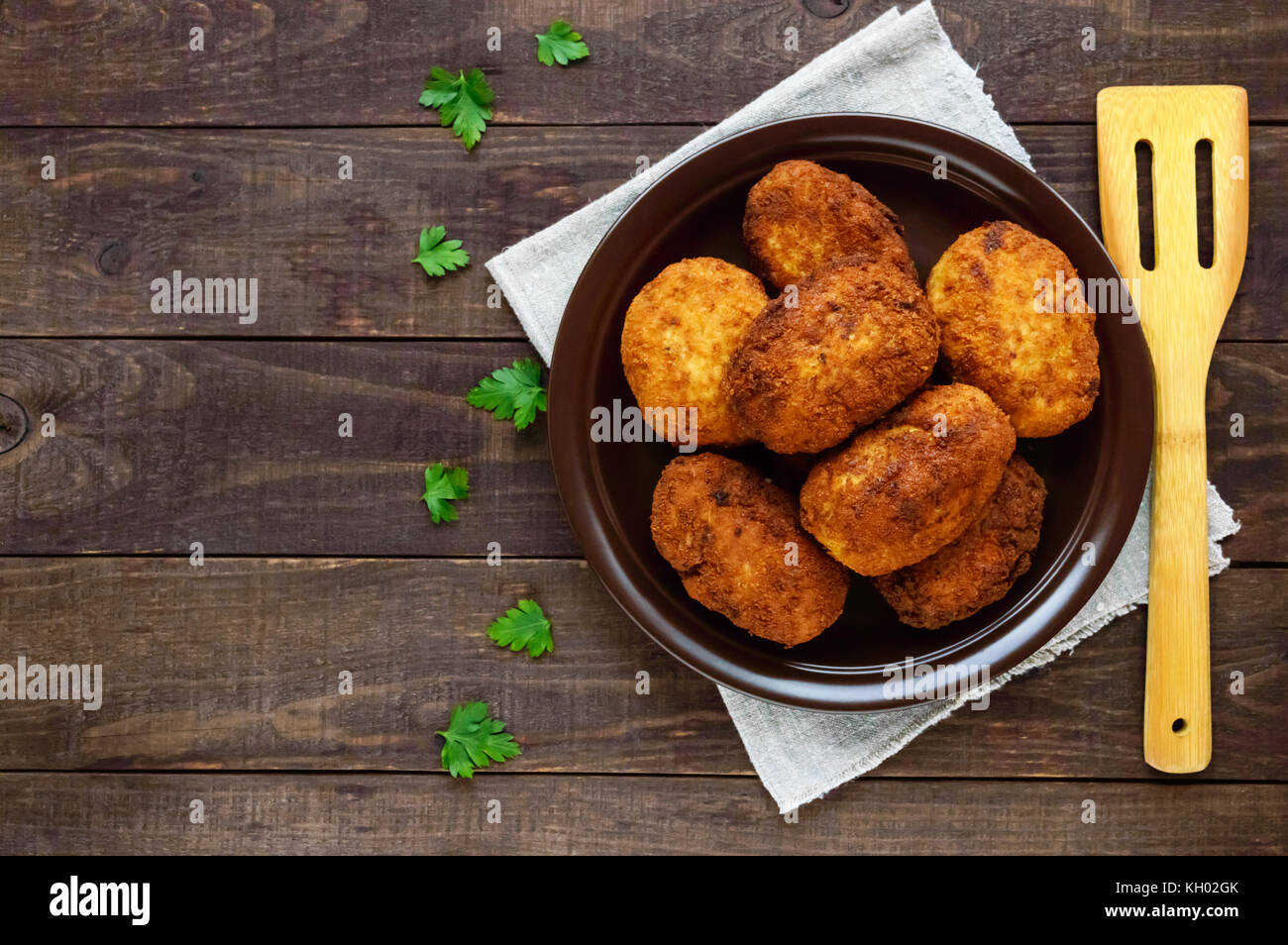 Meat mini-rolls (cutlet) with boiled egg in a clay bowl on dark wooden ...