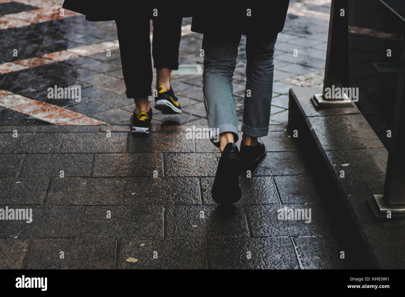 two fashionable people walking down the street Stock Photo - Alamy