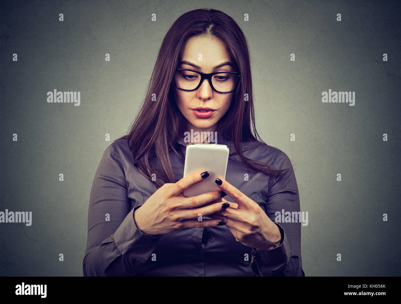 Serious woman using mobile phone Stock Photo - Alamy