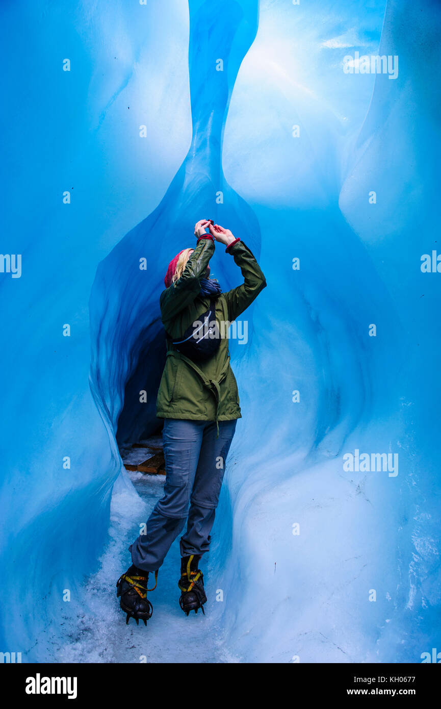 Woman photographing in a ice cave in Fox Glacier, South Island, New ...