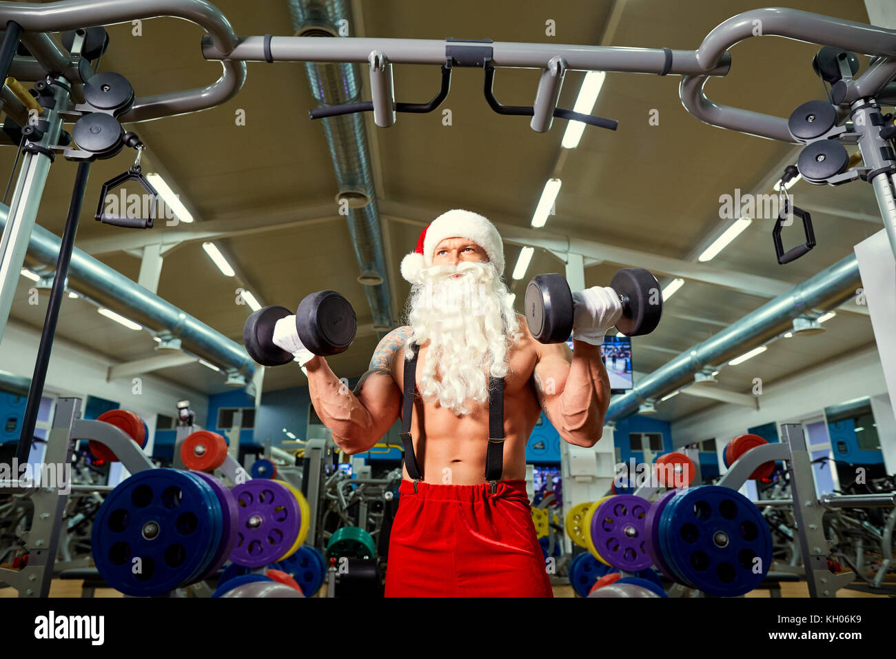 Santa Claus bodybuilder with dumbbells in the gym at Christmas Stock ...