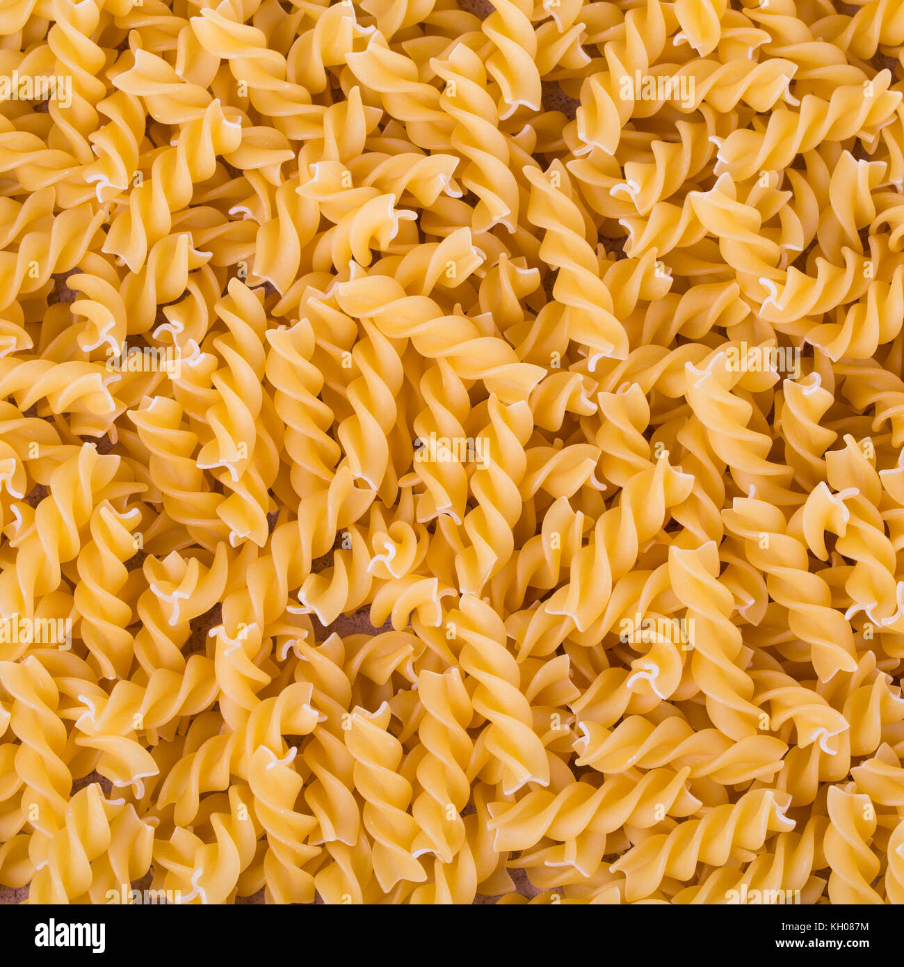 Raw pasta yellow close up background Stock Photo - Alamy
