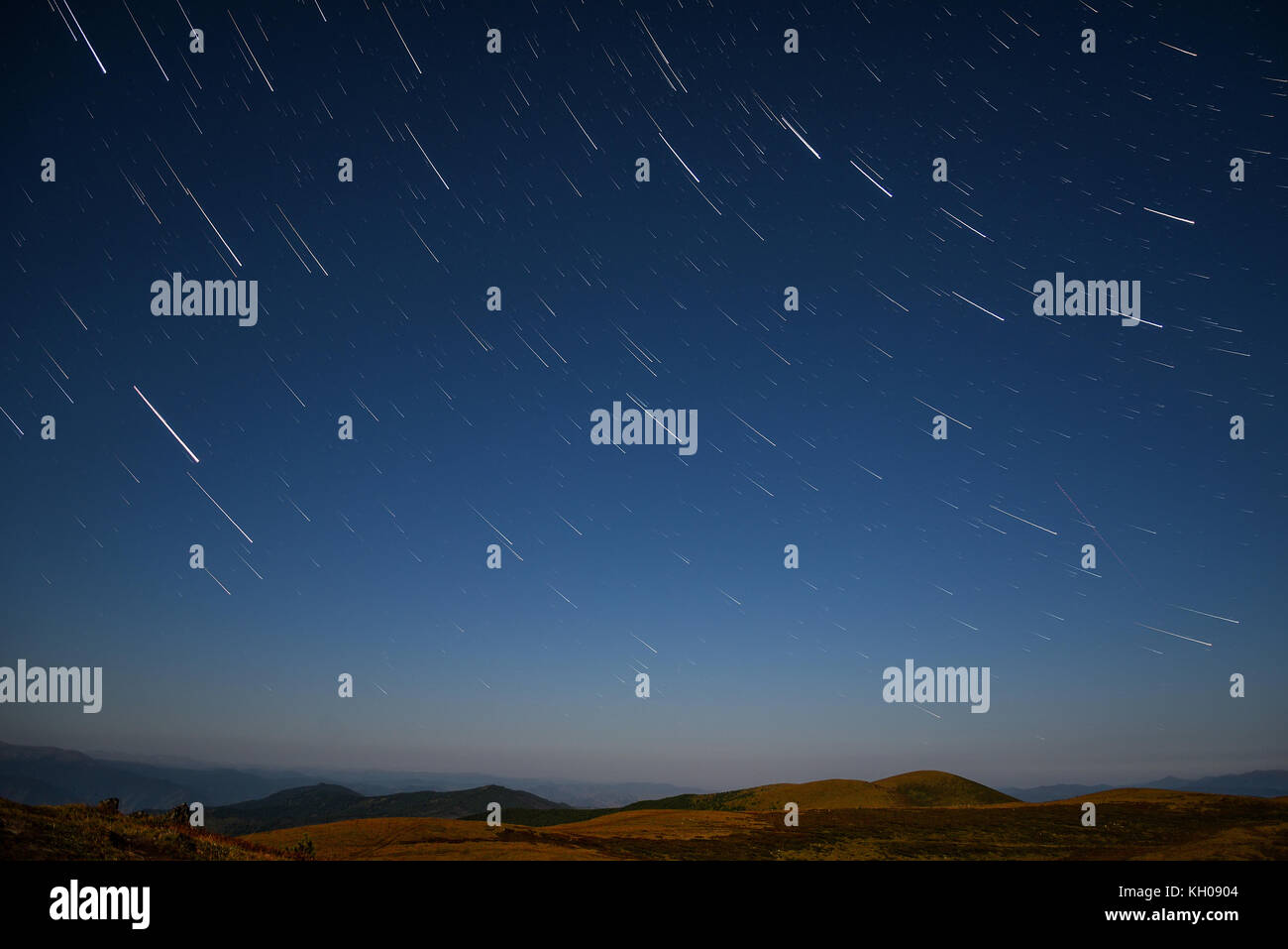 Beautiful night landscape with traces of stars in the night sky against ...