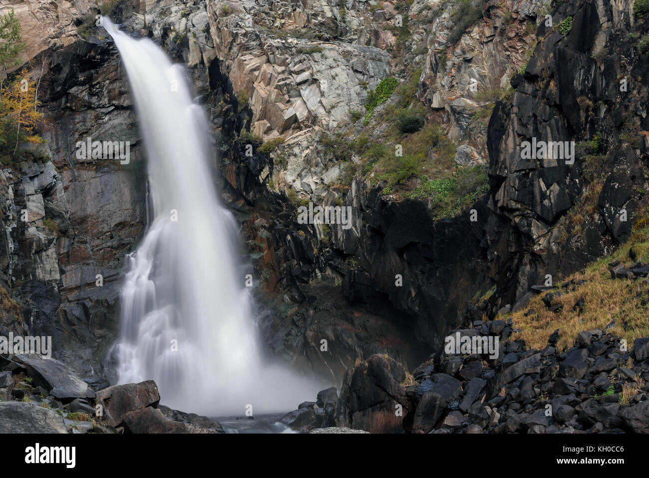Beautiful view of the waterfall with smooth water falling among the ...