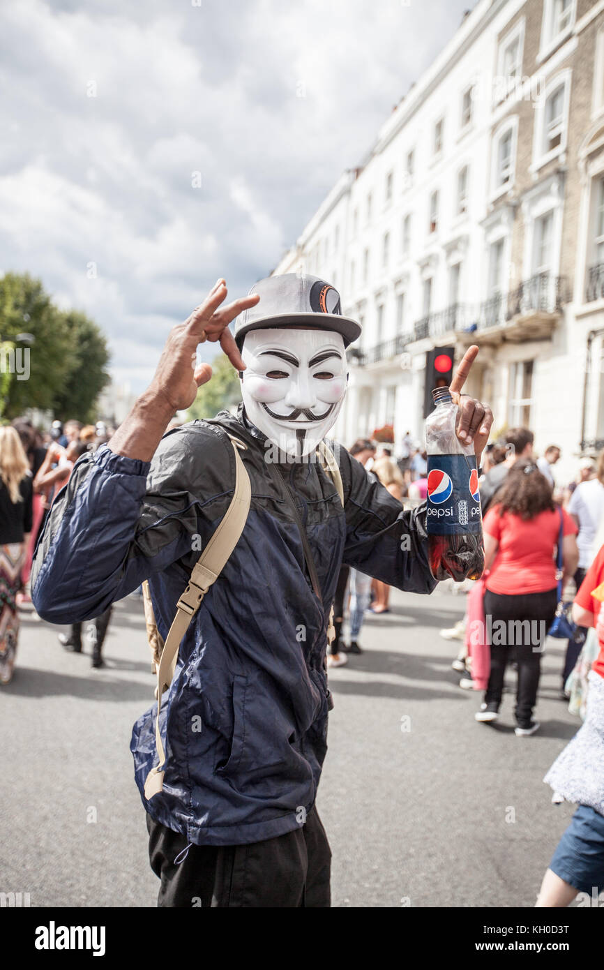 A carnival spectator wears a Guy Fawkes mask at the Notting Hill ...