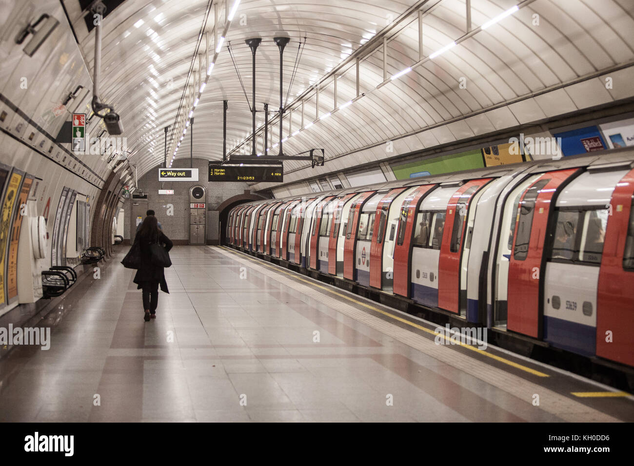 An almost abandoned tube station with only few passengers pictured in ...