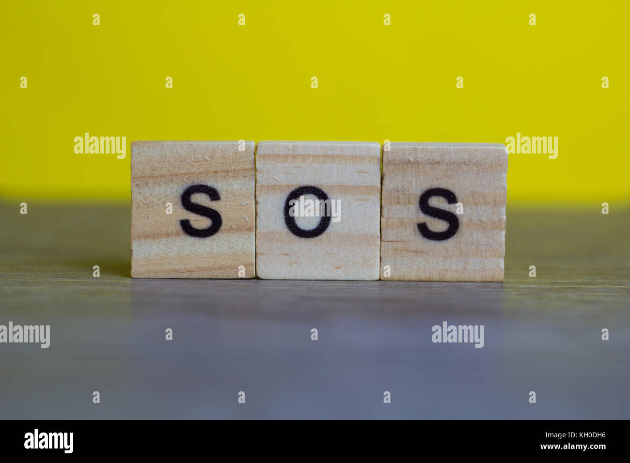 SOS word on wood cubes on table against yellow background Stock Photo ...
